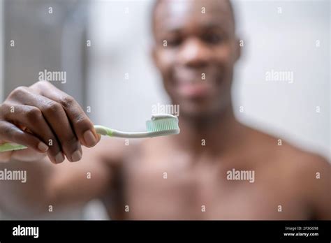 African American Short Haired Guy Looking At Himself In The Mirror