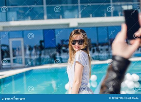 Young Pretty Girl With Long Hair And In Black Sunglasses Is Standing