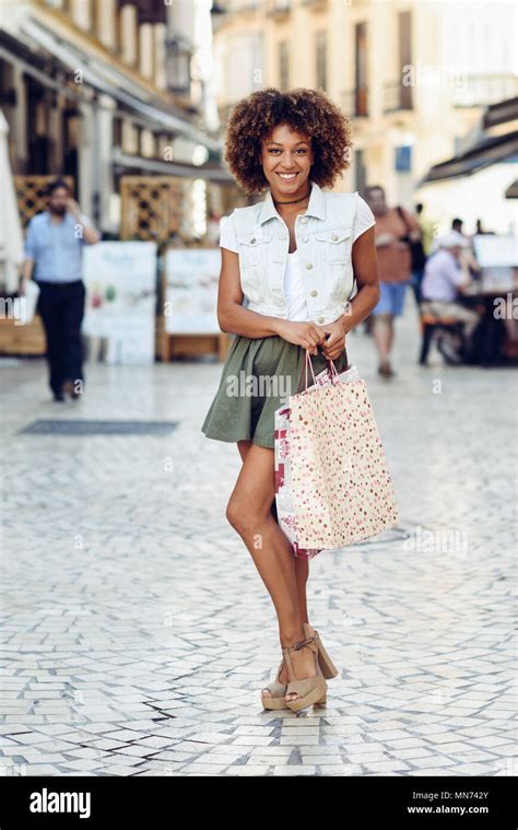 Young Black Woman Afro Hairstyle With Shopping Bags In The Street