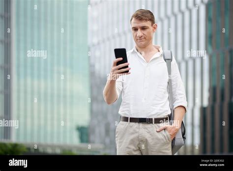 Portrait Of Confused Man Reading Text Message From Taxi Driver On
