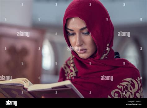 Muslim Woman Reading Koran Or Quran Wearing Traditional Dress At The