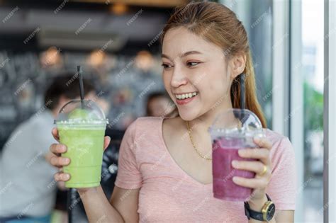 Premium Photo Woman Holding Glass Of Green Tea Frappe And Blueberry