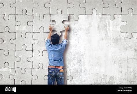 Man Making A Puzzle On The Wall Empty Wall With Space For Text Stock