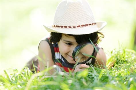 Niño Feliz Explorando La Naturaleza Con Lupa Foto Premium