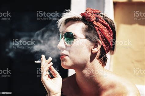 Portrait Of Young Blonde Pinup Girl With A Red Bow Smocking A Cigarette