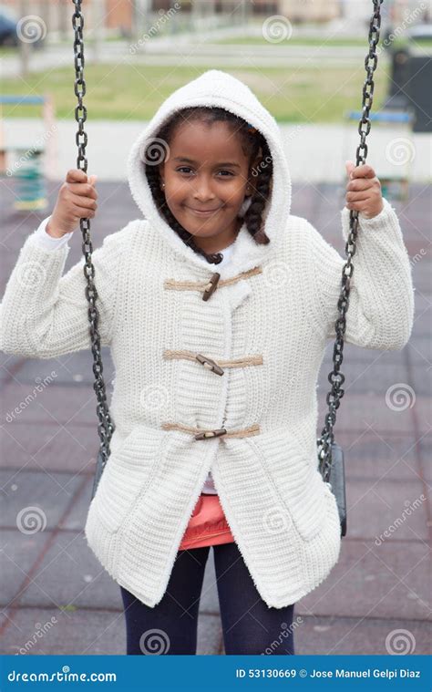 Outdoor Portrait Of A Cute Young Black Girl Playing With A Swing Stock