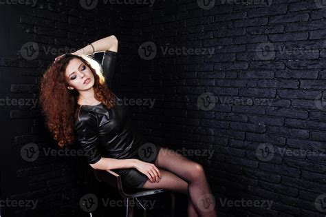 Brunette Curly Haired Long Legs Girl In Black Leather Dress Posed At