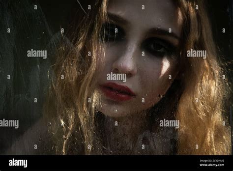 Beautiful Sad Young Girl Looking Out The Window With A Candle Good For