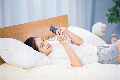 Female Lying On Bed Playing With Mobile Phone Picture And Hd Photos