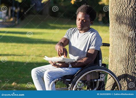 Young Man In Wheelchair Enjoying His Snack In Park Stock Image Image