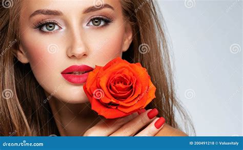 Beautiful Young Woman With A Red Flower In Hand Near Face Portrait Of