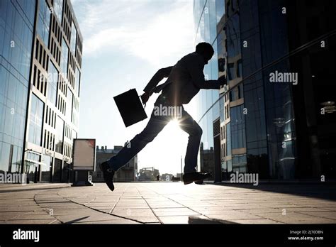 Silhouette Of African American White Collar Worker With Case Running