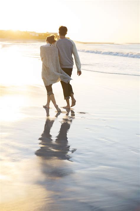 Young Couple Holding Hands And Walking On Beach At Sunset By Caia
