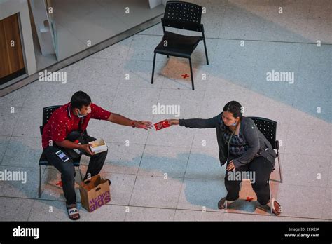 People Practice Social Distancing As They Sit On Chairs Spread Apart In