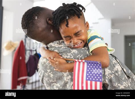 African American Father In Military Uniform Embraces A Joyful Son