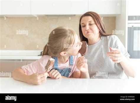 Mother With Daughter In Kitchen Eating Ice Cream Good Relations Of
