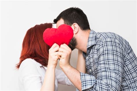 Free Photo Young Couple Kissing Behind Red Heart