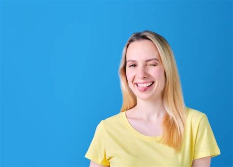 Premium Photo Blonde Girl In Yellow Tshirt Winking With Tongue Out