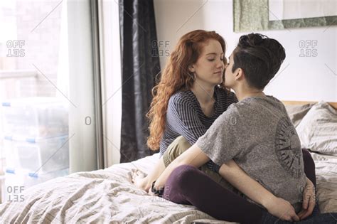 lesbians romancing while relaxing on bed at home stock