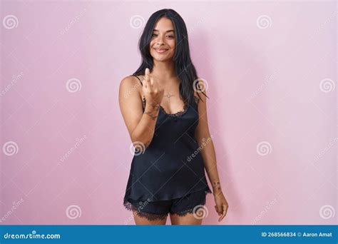 Brunette Woman Wearing Black Pajama Beckoning Come Here Gesture With