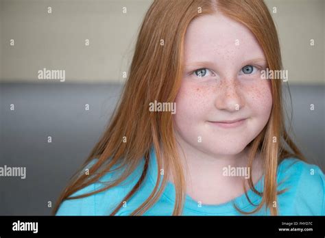 Red Haired Blue Eyed Girl With A Slight Smile Wearing A Blue Shirt