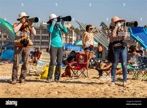 Male And Female Asian American Amateur Photographers Focus On A July