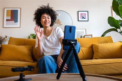 Premium Photo Happy Mixed Race Female Vlogger Waves Hand During Vlog