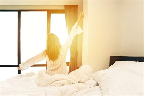Premium Photo Rear View Of Woman Stretching In Bed After Wake Up In