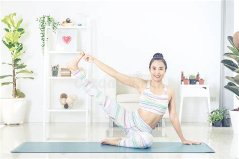 Beautiful Asian Sports Woman Performs The Exercises At Home Yoga Stock
