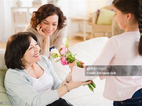Granddaughter Giving Grandmother Bouquet Of Flowers High Res Stock