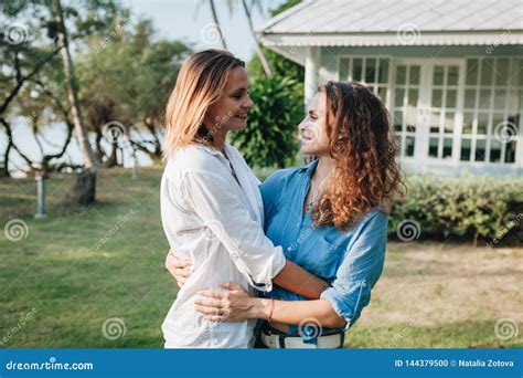 Happy Lesbian Couple Hugging In The Garden At Their Country House Stock