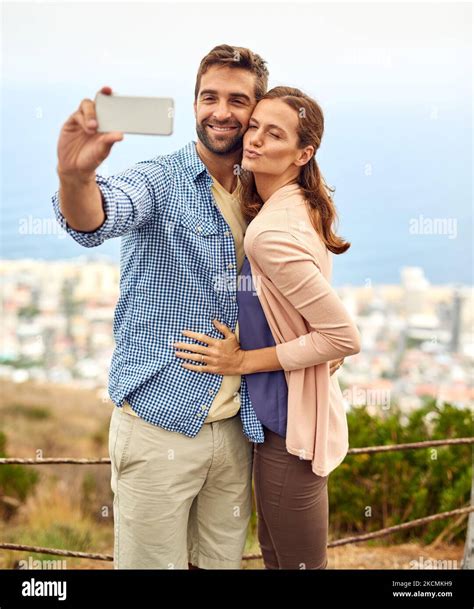 Sharing Some Selfie Love An Affectionate Couple Taking Selfies Outside