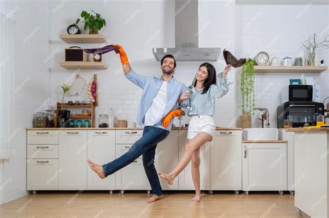 Premium Photo Couple Having Fun While Housekeeping Apartment Together