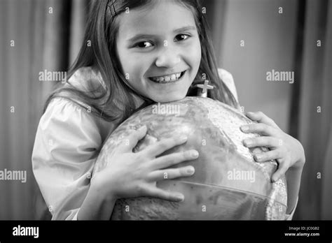 Black And White Portrait Of Smiling Girl Posing With Big Earth Globe