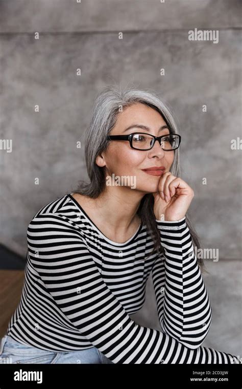 Photo Of Pleased Gray Haired Asian Woman Wearing Eyeglasses Looking