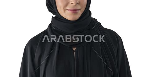 بورتريه لإمرأه عربية خليجية إماراتيه مبتسمة تقف بإستقامه، تنظر إلى شيء