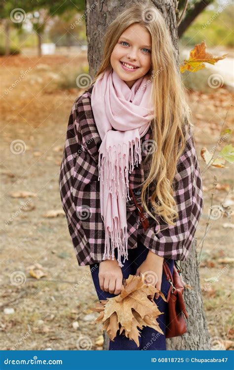 La Jeune Fille Mignonne Est Arbre Proche Debout En Automne Image Stock
