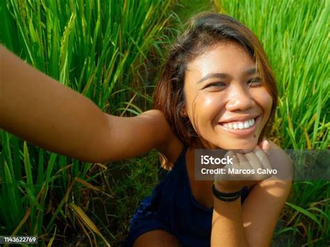 Young Happy And Exotic Islander Asian Girl From Indonesia Taking Selfie