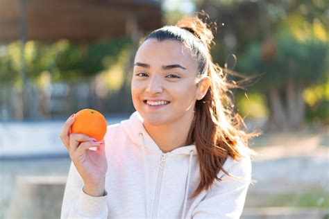 Premium Photo Young Pretty Brunette Woman Holding An Orange At