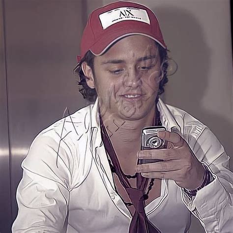 A Man Taking A Selfie With His Cell Phone While Wearing A Hat And Tie