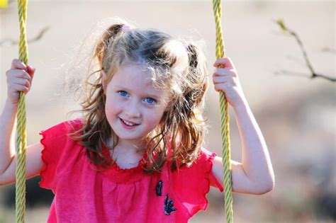 Premium Photo Portrait Of Cute Girl On Swing At Park