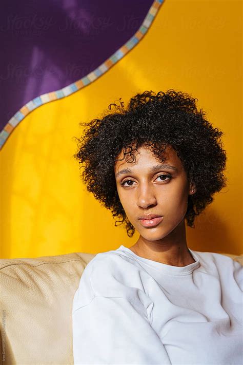 View Close Up Afro Women In Front Of A Bright Wall By Stocksy