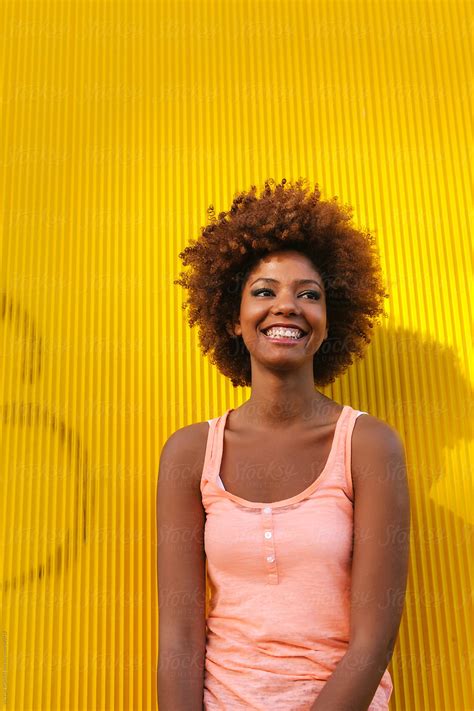 Latin American Afro Woman Against A Yellow Background In A Summer Day