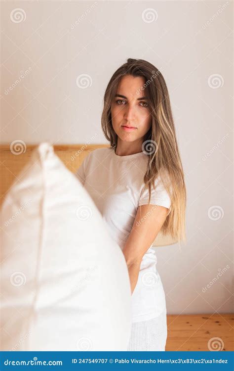 Young Beaituful Woman Showing The Pillow Of The Bed To Camera And