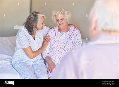 Girlfriend Comforts Senior Citizen With Dementia On The Bed In Hospital