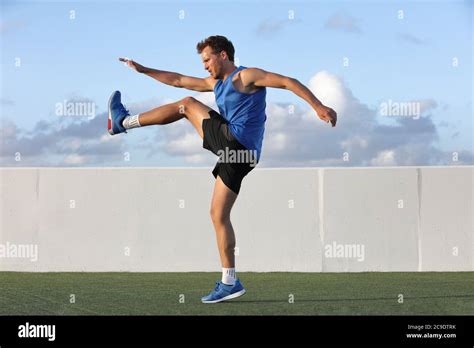 Runner Man Getting Ready To Run Doing Warm Up Dynamic Leg Stretch