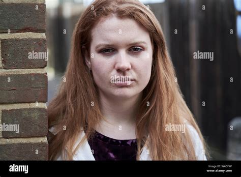 Portrait Of Serious Teenage Girl Leaning Against Wall In Urban Setting