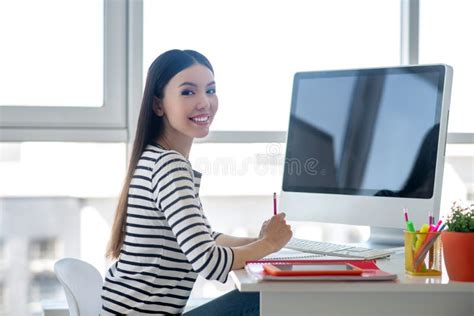Dark Haired Pretty Woman In A Striped Shirt Smiling Nicely Stock Image