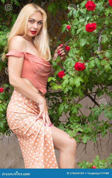 Beautiful Woman With Long Blonde Hair And Red Lips Wearing Pink Clothes