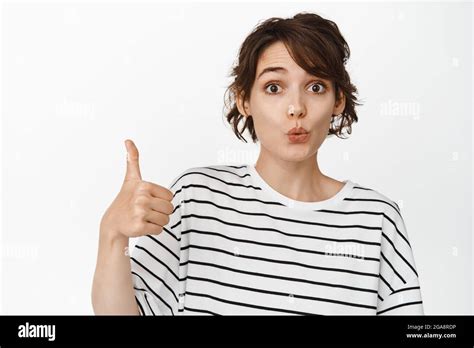 Surprised Brunette Woman Shows Thumbs Up And Look Excited Like